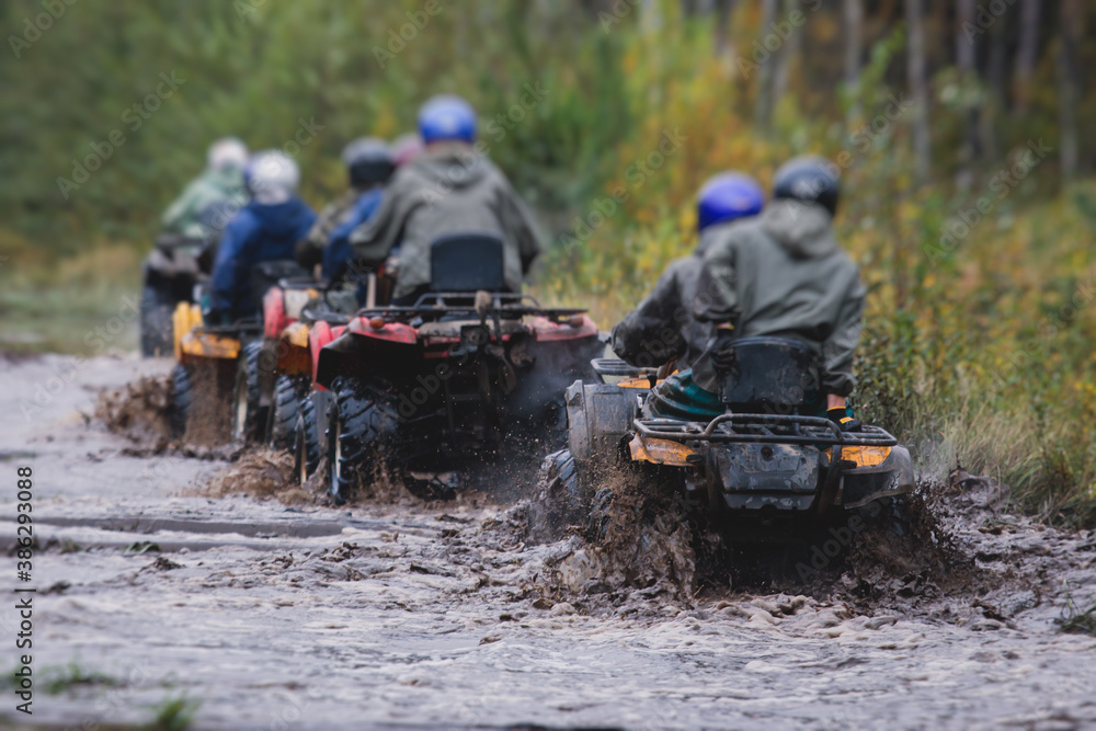 Group of riders riding atv vehicle on off road track, process of ...