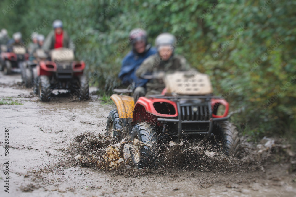 Group of riders riding atv vehicle on off road track, process of ...