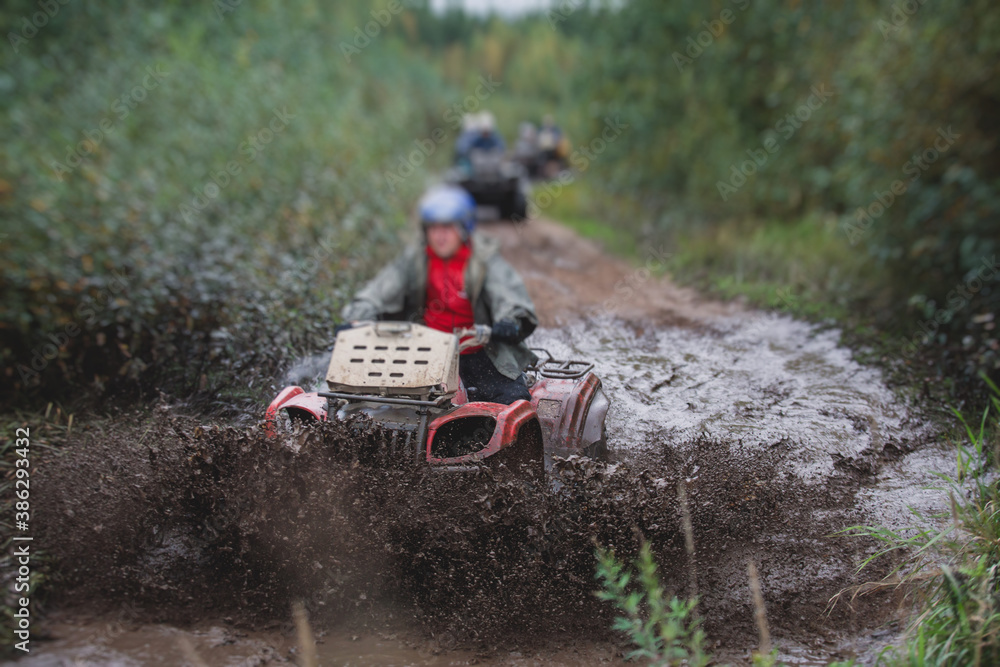 Group of riders riding atv vehicle on off road track, process of ...