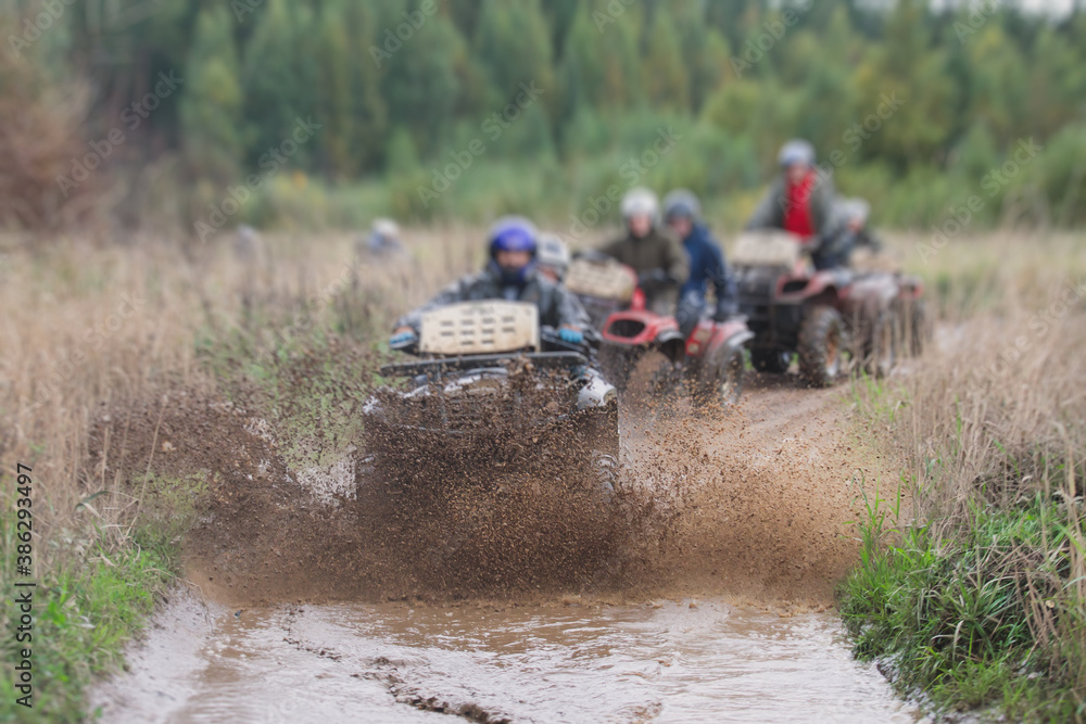 Group of riders riding atv vehicle on off road track, process of ...