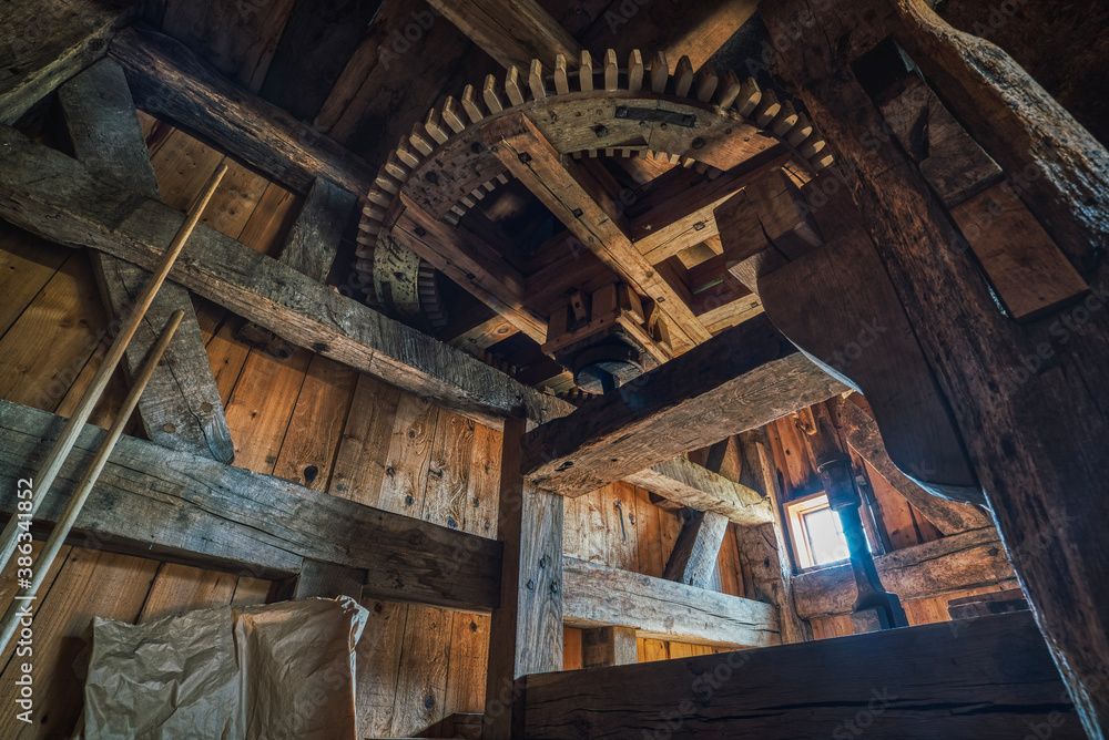 A wooden cog set in motion by the rotating blades of an historical wind ...