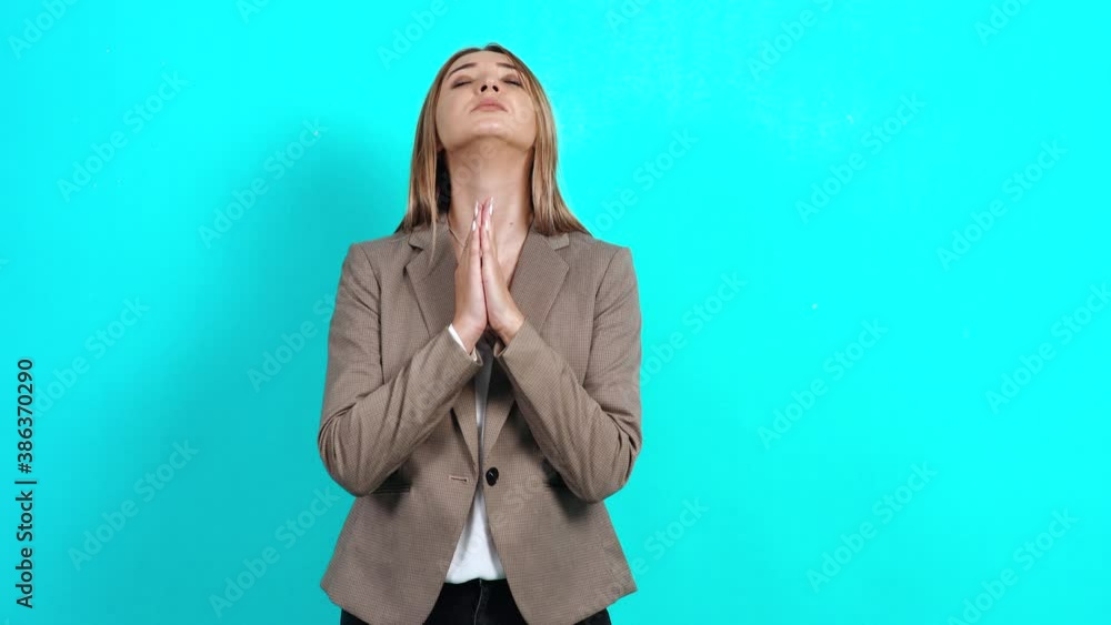 Young woman in business suit holding hands in prayer, asking for help ...