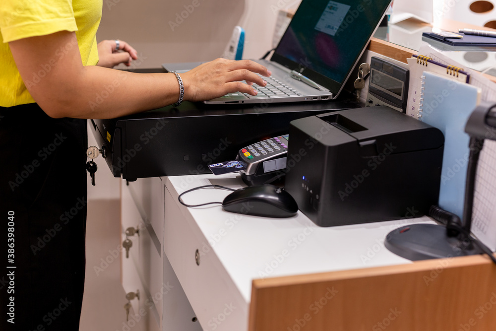 Hand typing keyboard on laptop with credit card in card reader at ...