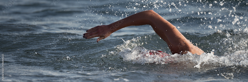 Arm of a swimmer athlete swimming in the ocean, competition swimming at ...