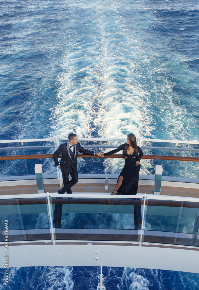 Foto de Young beautiful elegant couple standing on a deck of cruise ...