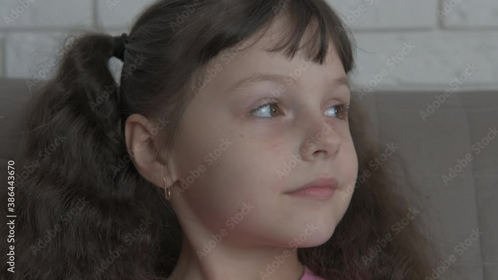 Child look at camera and smile indoor. A happy little girl look in the ...