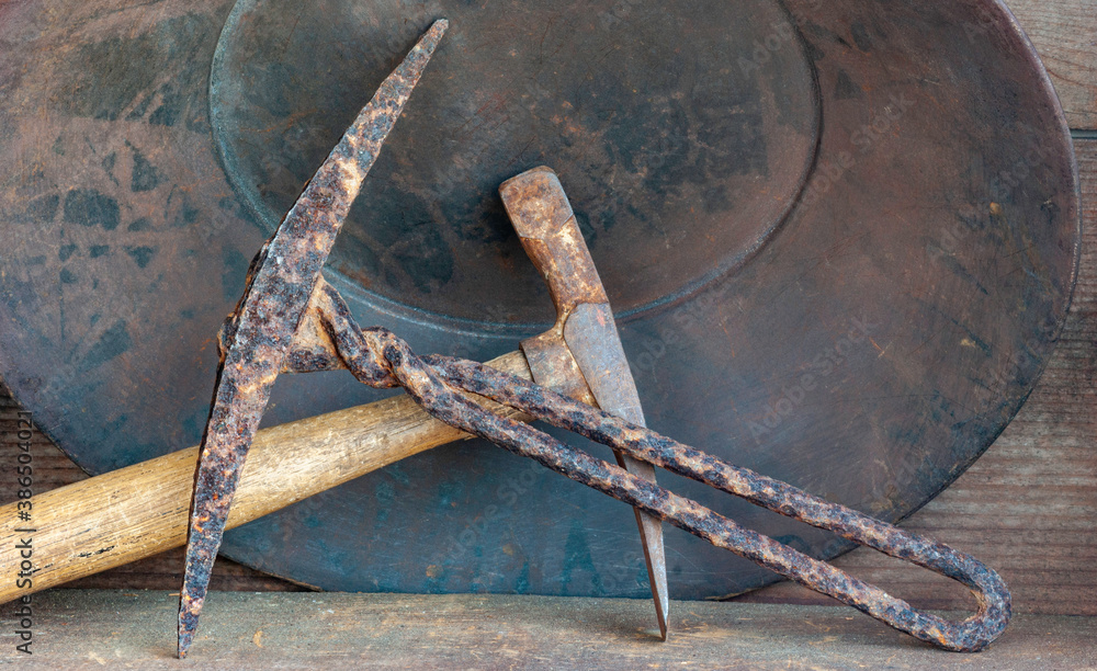 Antique mining picks with rust and gold pan background. Space for text ...