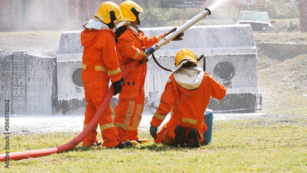 Firefighter fighting with flame using fire hose chemical water foam ...