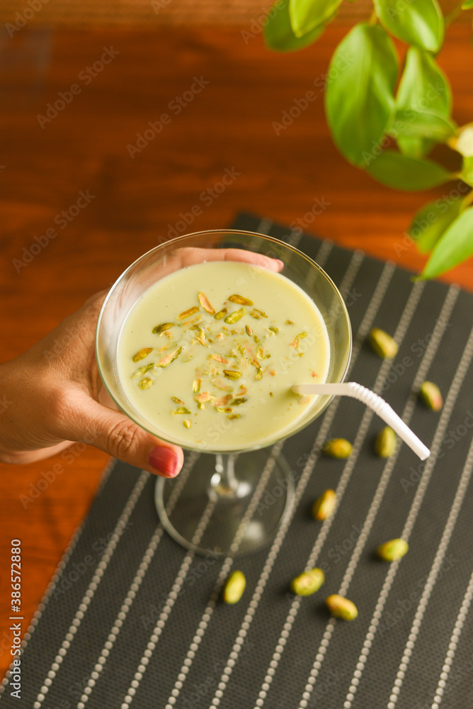 Pista Badam milk shake or Almond Pista milk Kerala India. Woman taking ...