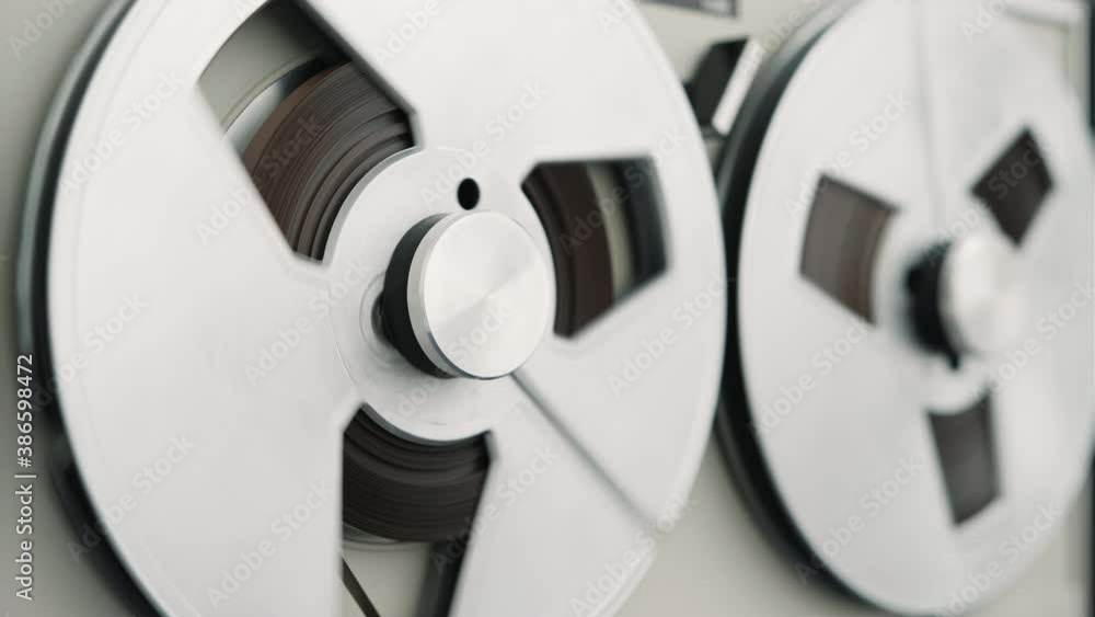 Tape reels rotating of retro tape recorder. Vintage music player close ...