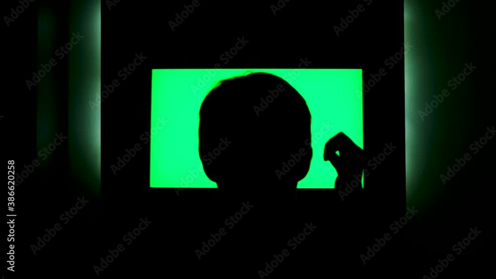 Video Stock Rear view of a male head silhouette in front of tv with ...