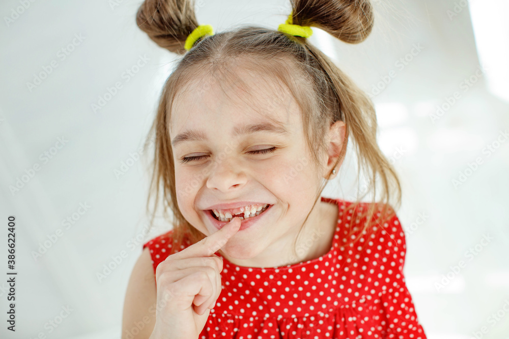 Fotka „A beautiful little girl lost the first milk tooth. Loss of ...