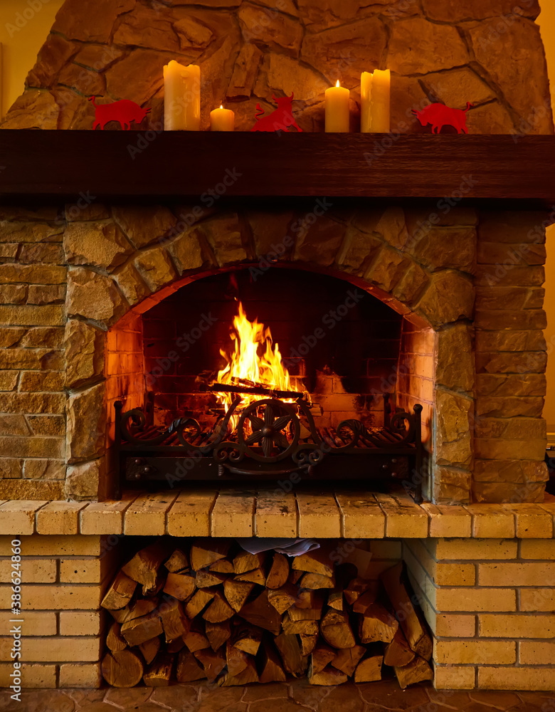 Warm cozy fireplace with real wood burning in it. Cozy winter concept ...