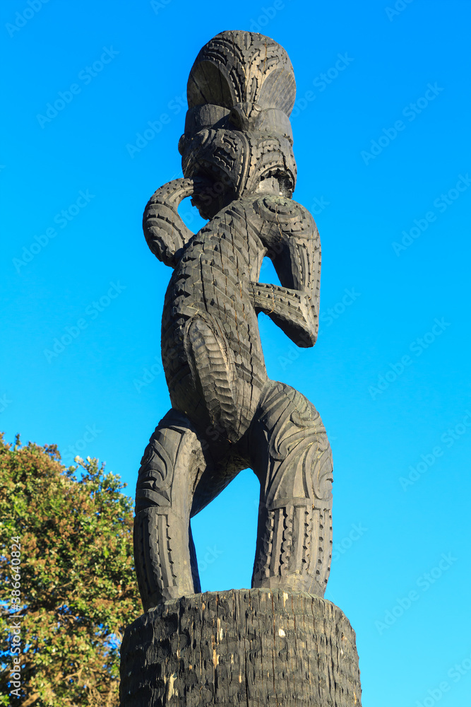 Traditional Maori wood carving of a human form in a park in Tauranga ...