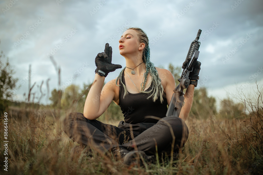 Sexy woman posing with rifle outdoors conceive of smoke from barrel ...