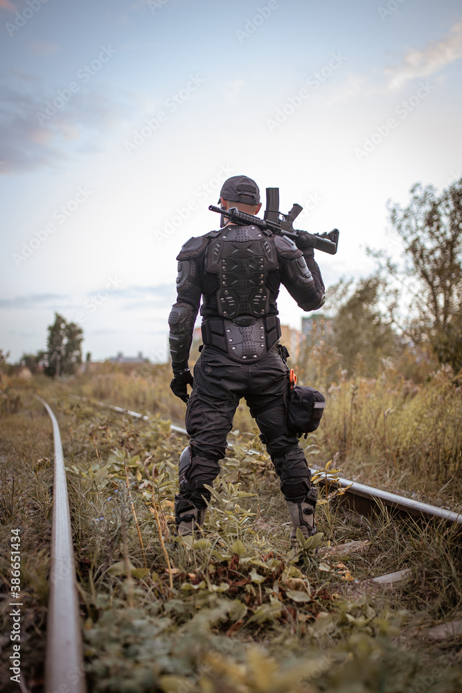 a man with a rifle in uniform stands with his back Stock Photo | Adobe ...