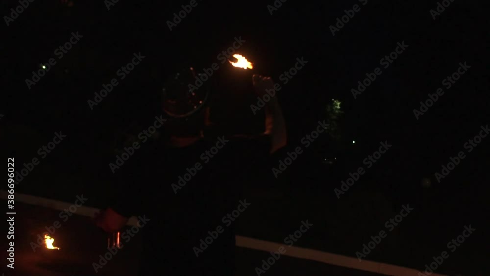 Man shows dangerous tricks with fire in fire show at night, background ...