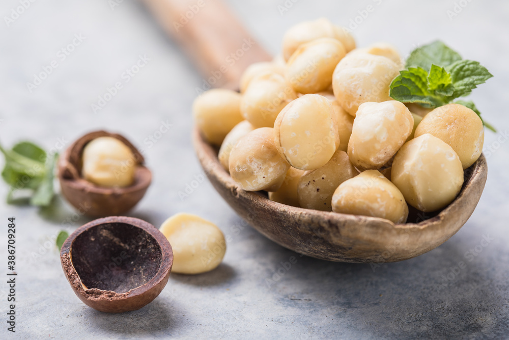 Pile macadamia nuts open kernels and shells in spoon on concrete ...