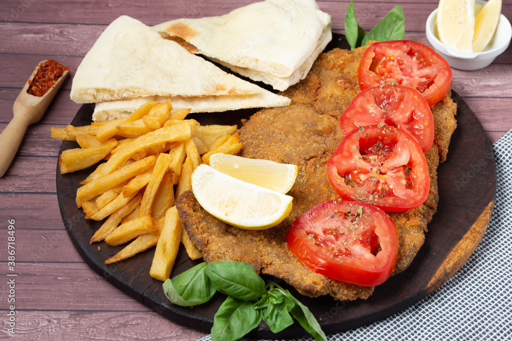 milanesa gigante con papas fritas Stock Photo | Adobe Stock