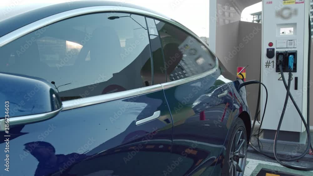 Electric Car Charging At A Charging Station. Panning close up shot of ...