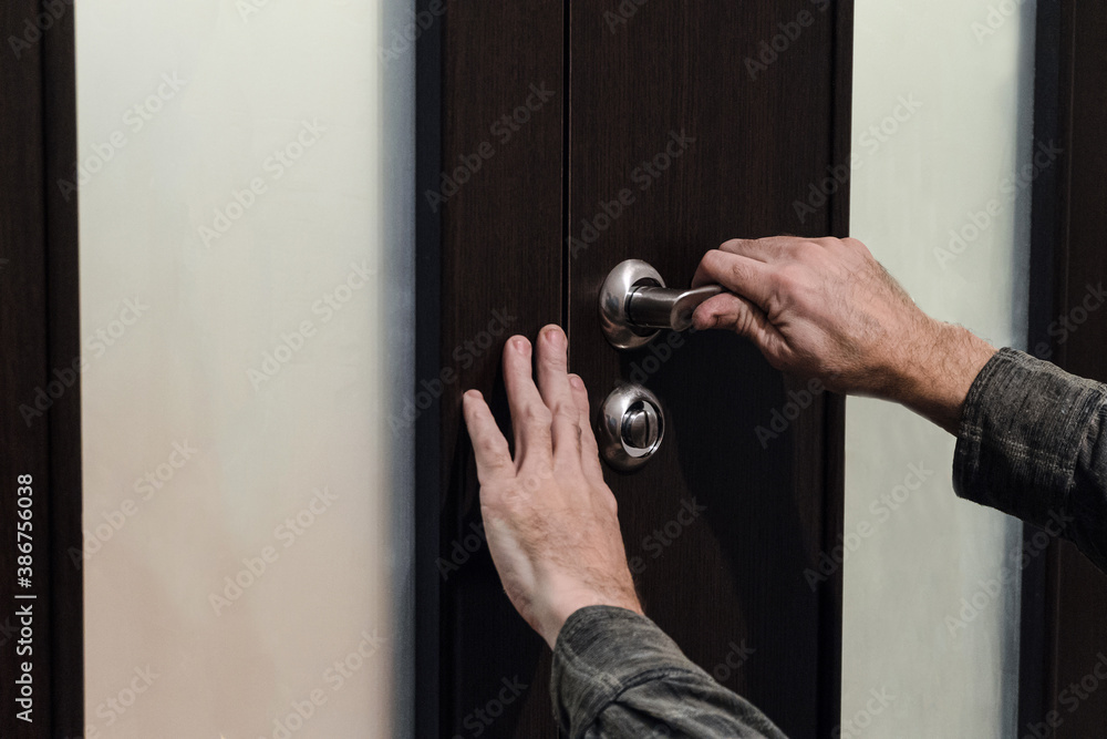 Hands closing the double door. A man carpenter checks the door sheet ...