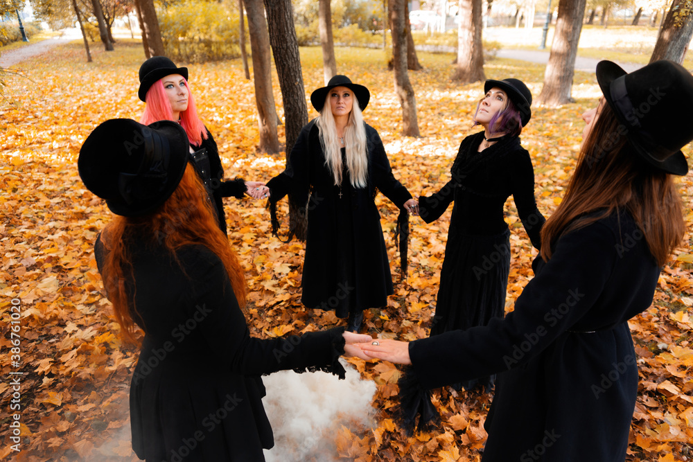 Coven of witches, a group of friends as witches on Halloween perform a ...