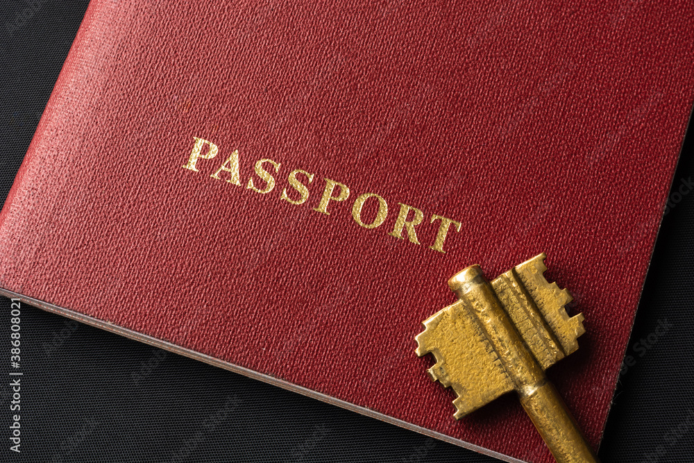 Golden key on foreign passport against black background. Borders ...