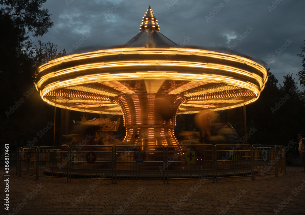 Illuminated retro carousel at night. Merry Go Round in low speed ...