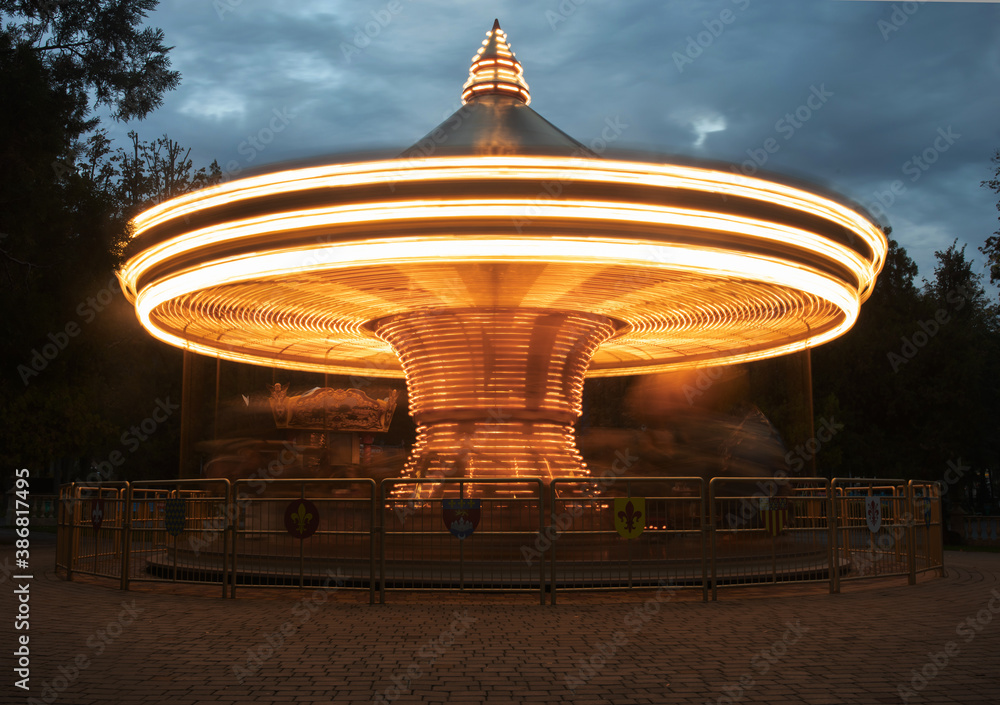 Illuminated retro carousel at night. Merry Go Round in low speed ...