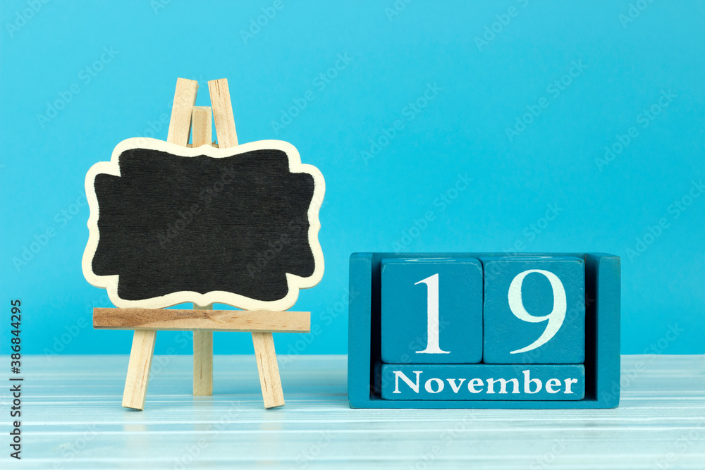 wooden calendar with the date of November 19 and an easel on a blue ...