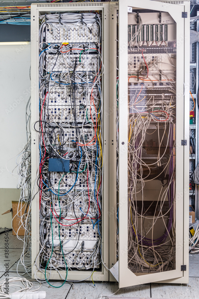 server room rack with tangled network cables creating messy unti Stock Photo | Adobe Stock