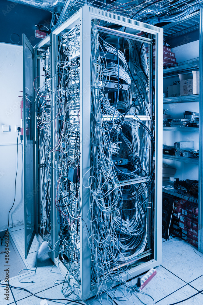 server room rack with tangled network cables creating messy unti Stock Photo | Adobe Stock