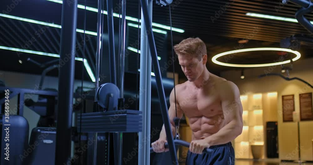 Sportsman trains the triceps of the arms on the simulator, extension of ...