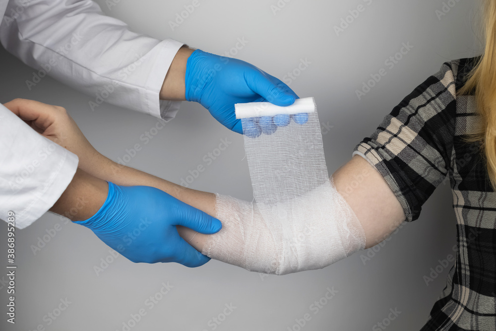 Foto de The traumatologist puts a bandage on the elbow of the female ...