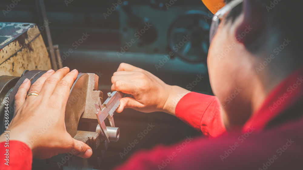 Asian man foreman working with vernier caliper and NC Lathe machinery ...