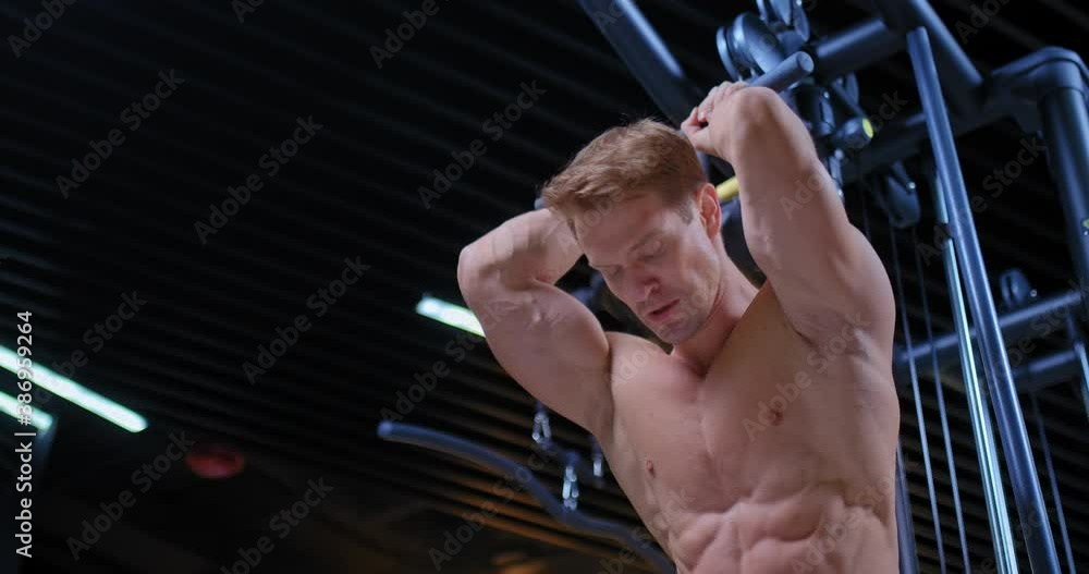 Bodybuilder athlete makes a power pull of the upper block for the head ...