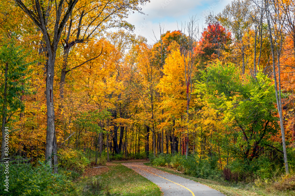 A walking and biking trail, with a yellow line down the center, winds ...