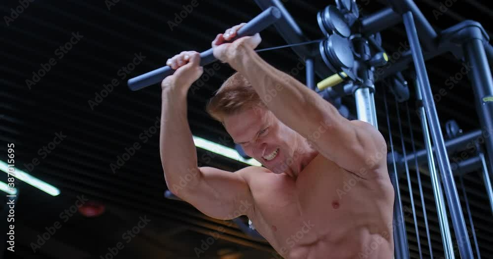 Young bodybuilder trains on a power rack, does a row for the head ...