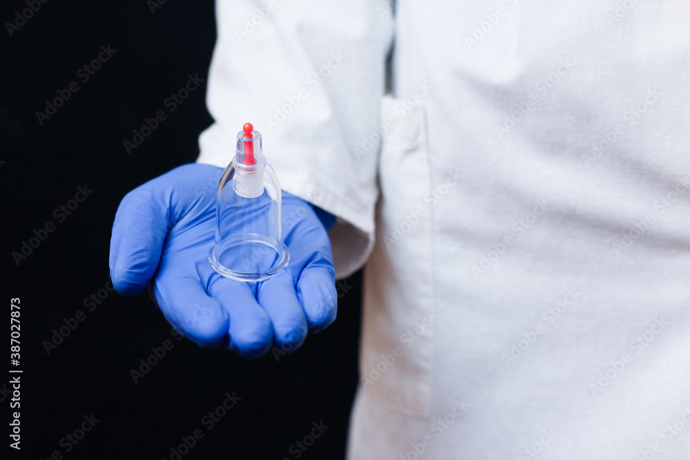 Jars for hijama bloodletting in the hands of a doctor in a white coat ...