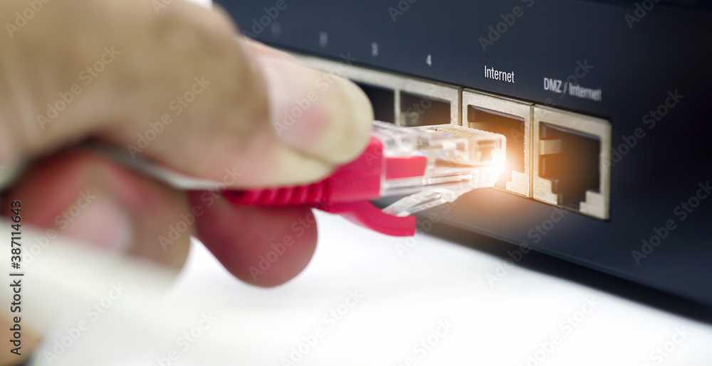 Foto de Man plugs internet cable into the router.LAN network and ...
