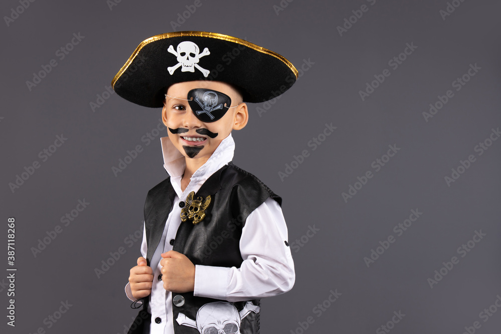 Little boy dressed as a pirate with makeup on his face is having fun at ...