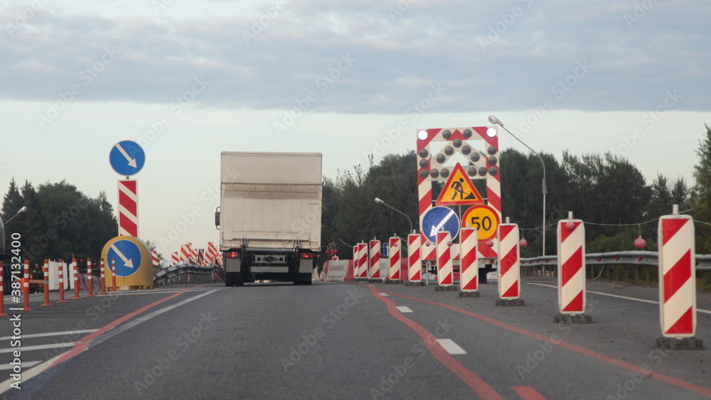 Van truck move on suburban highway road near works section with ...