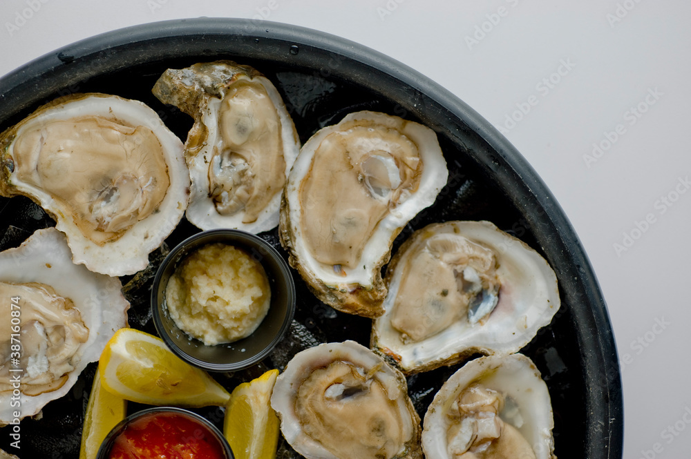 Oysters on the half shell. Fresh oysters served with garlic, shallots ...
