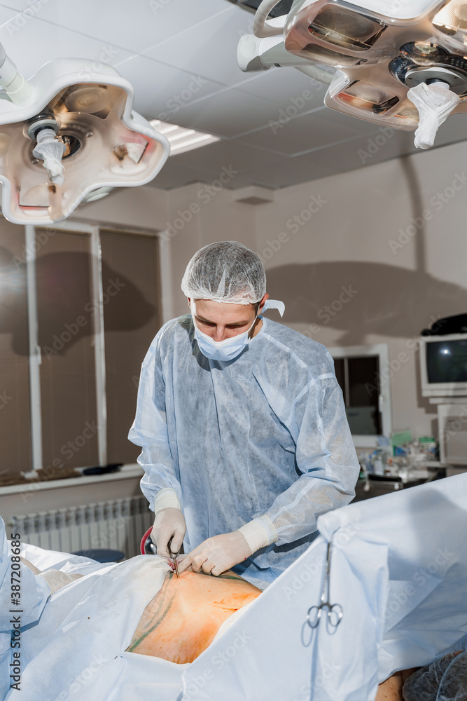 Surgeon removes fat in the gluteal region. Abdominoplasty - plastic ...