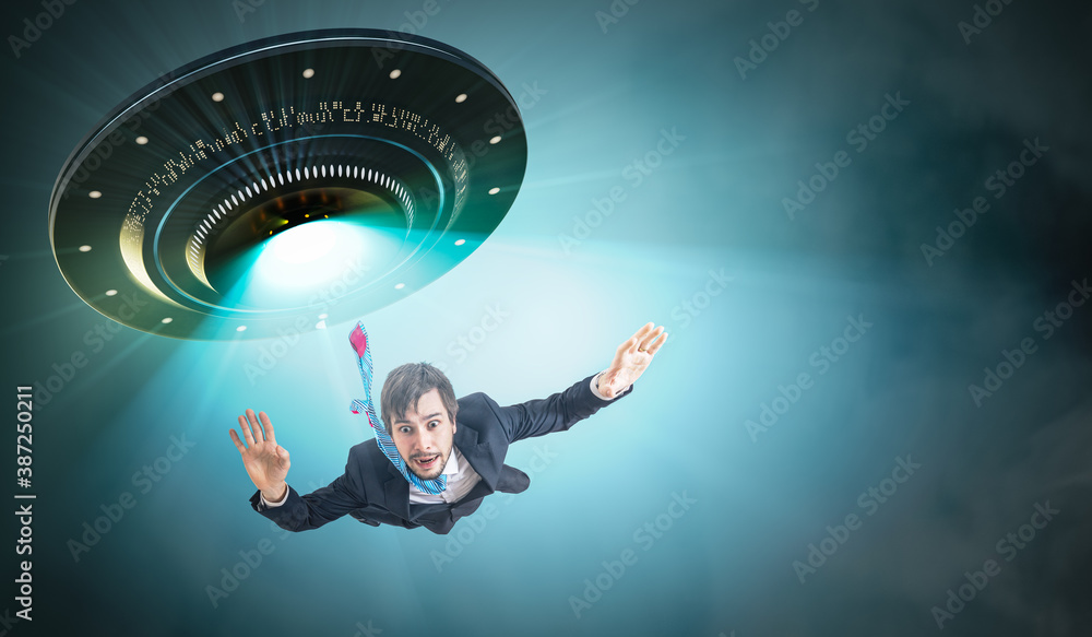Alien abduction concept. Young man is abducted by UFO. Stock Photo ...
