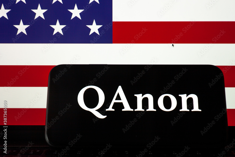 QAnon organisation logo seen on the smartphone which is placed on USA ...