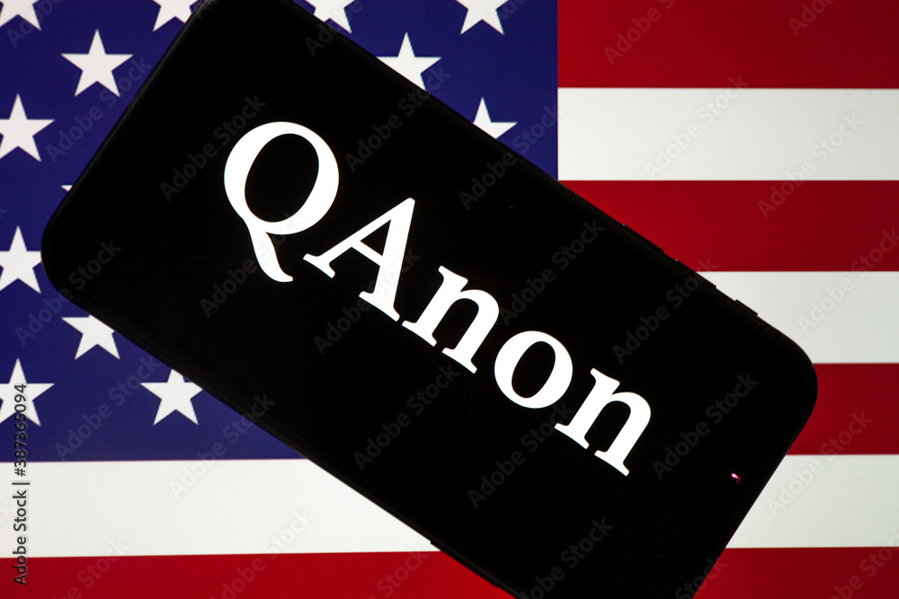 QAnon organisation logo seen on the smartphone which is placed on USA ...