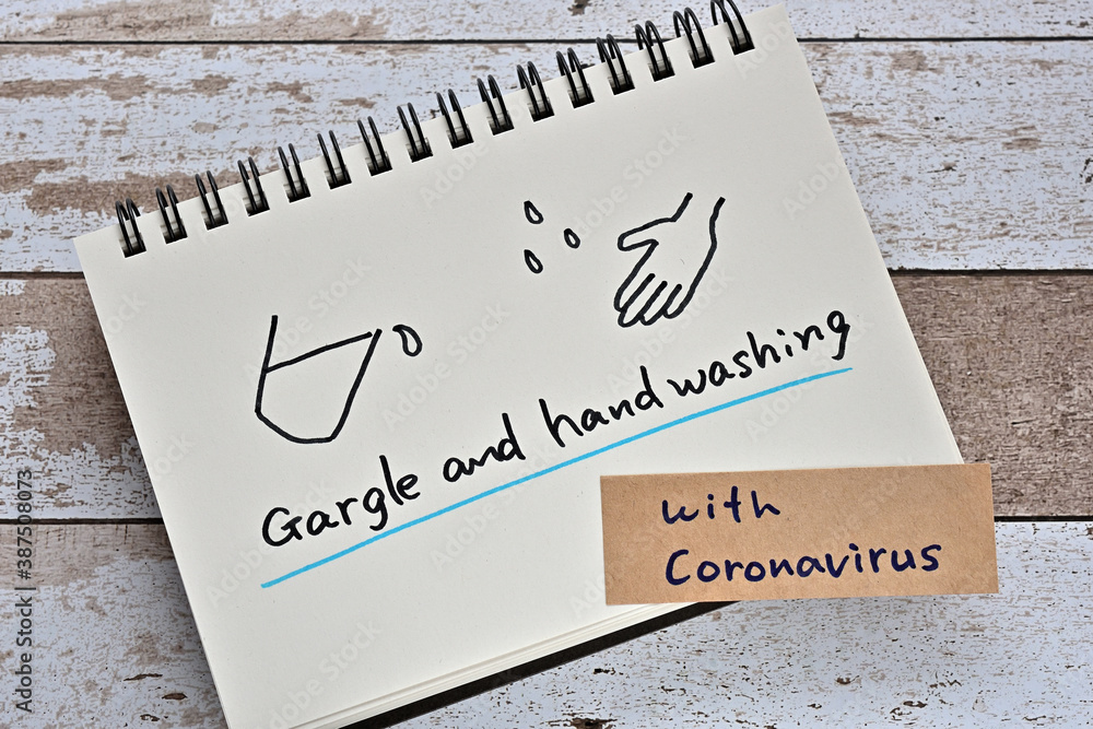 There is a sticky note with the words "with Coronavirus" on a notebook ...