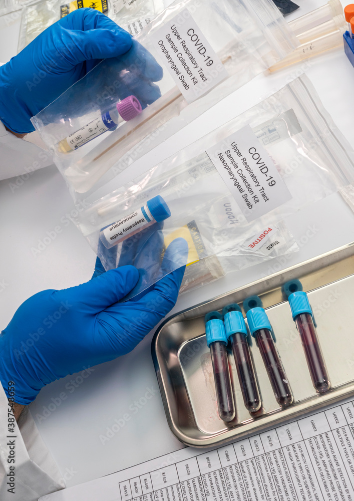 Nurse comparing positive covid-19 test results of infected persons ...