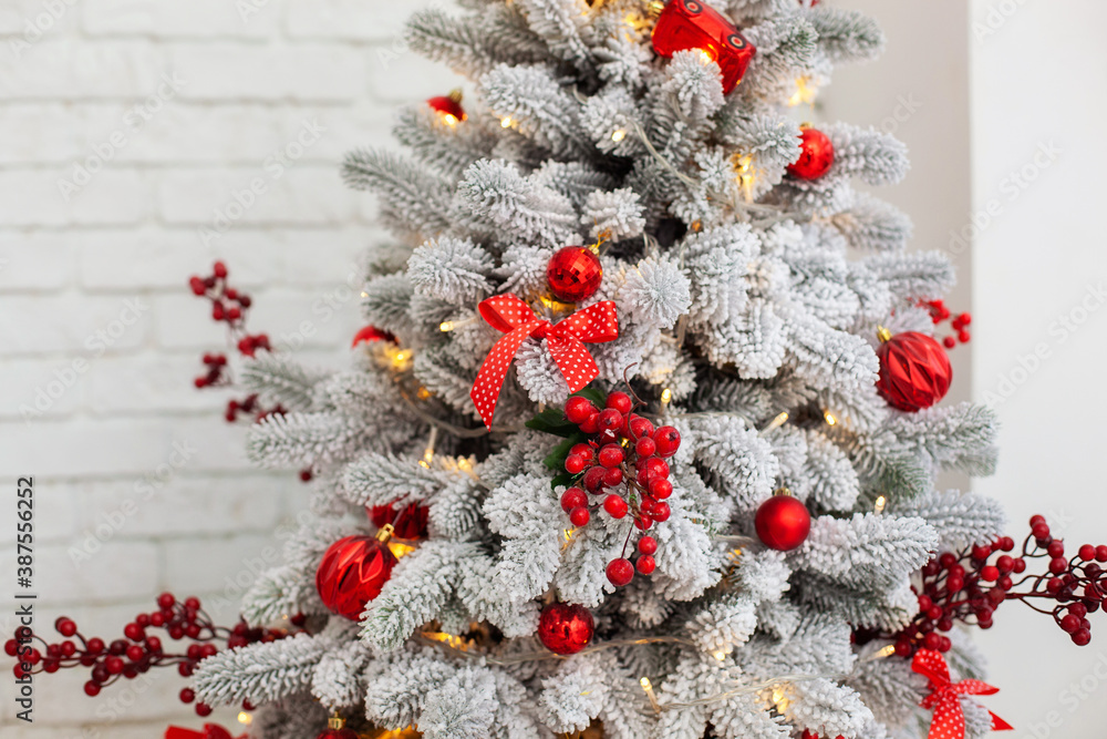 Xmas snow tree decorated with toys, branches of red berries, balls and ...